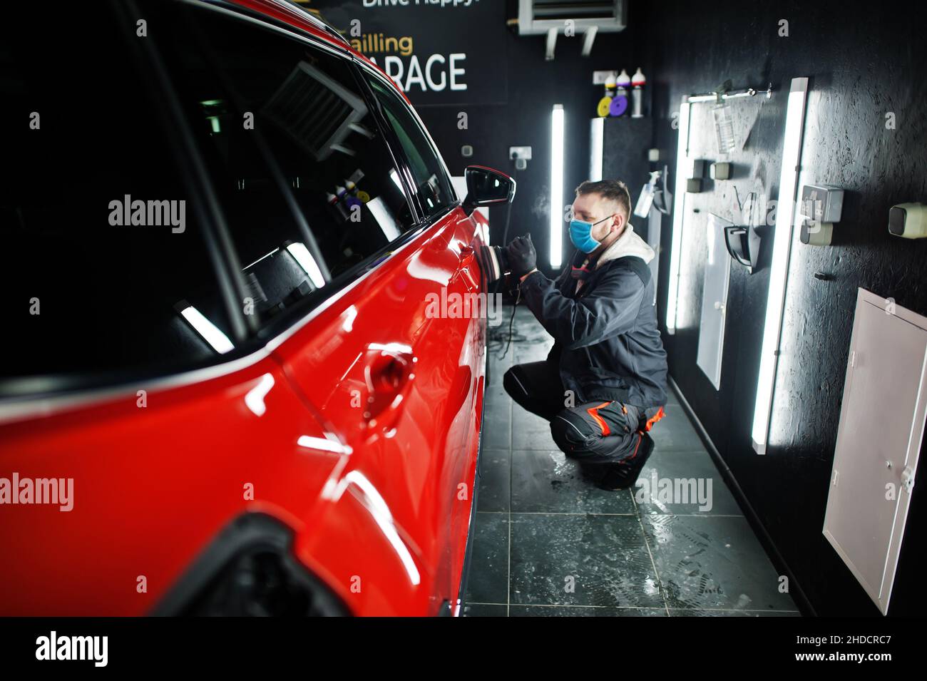 Car detailing concept. Man in face mask with orbital polisher in repair ...
