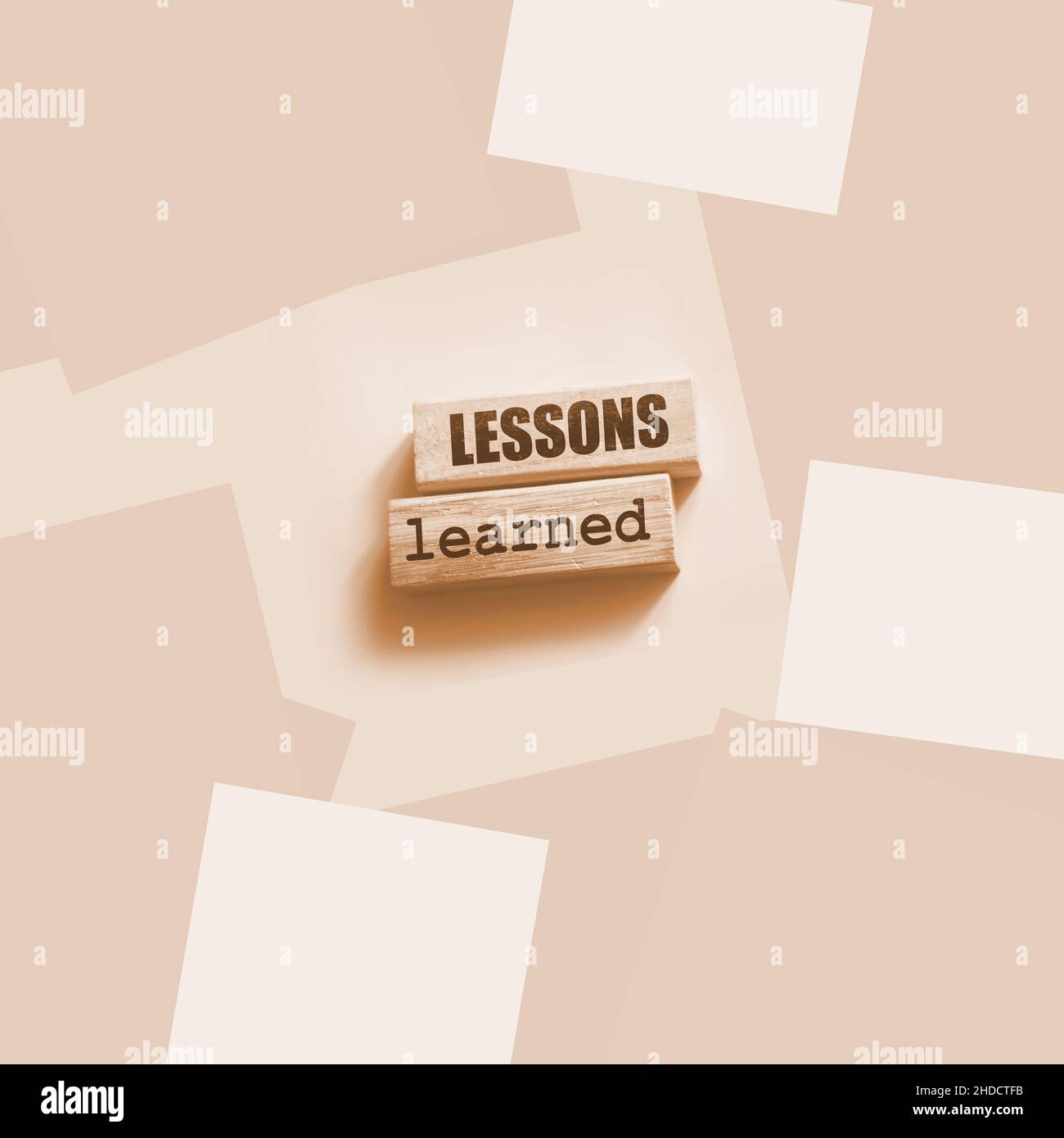 Wooden blocks wtih text Lessons learned on pink background. Business ...