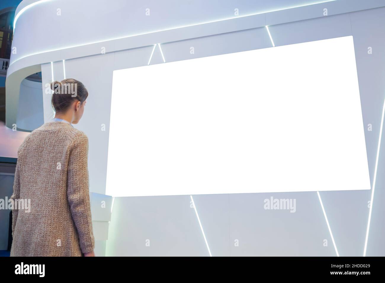 Woman looking at blank white display wall at exhibition - white screen ...