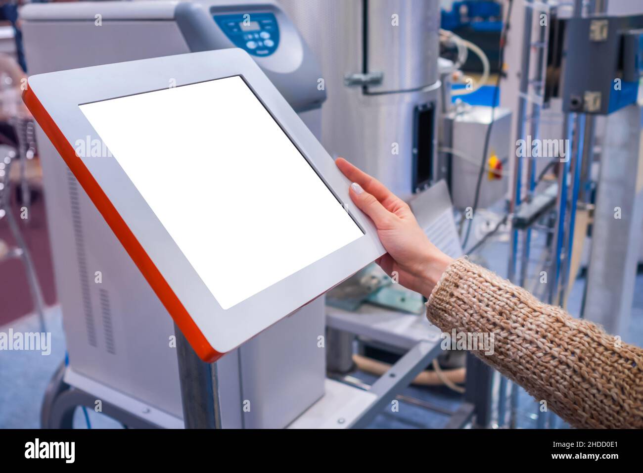 Woman using interactive empty white touchscreen display kiosk at ...