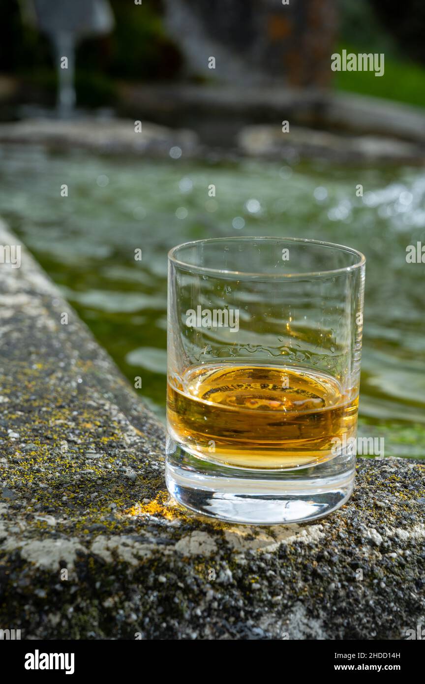 Glass of strong scotch single malt whisky served on old stone reservoir ...