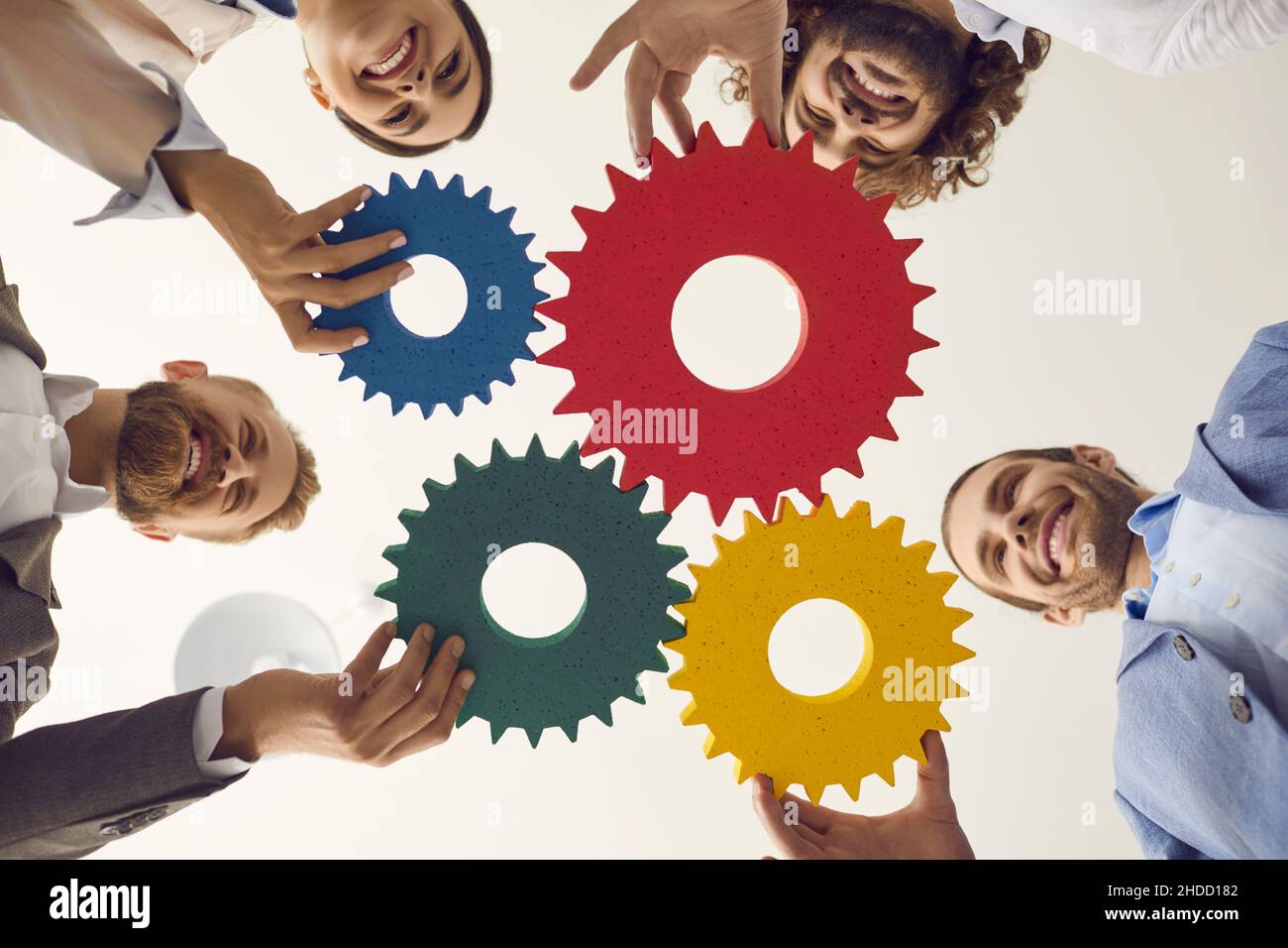 Business team joining cog wheels to illustrate concept of effective ...