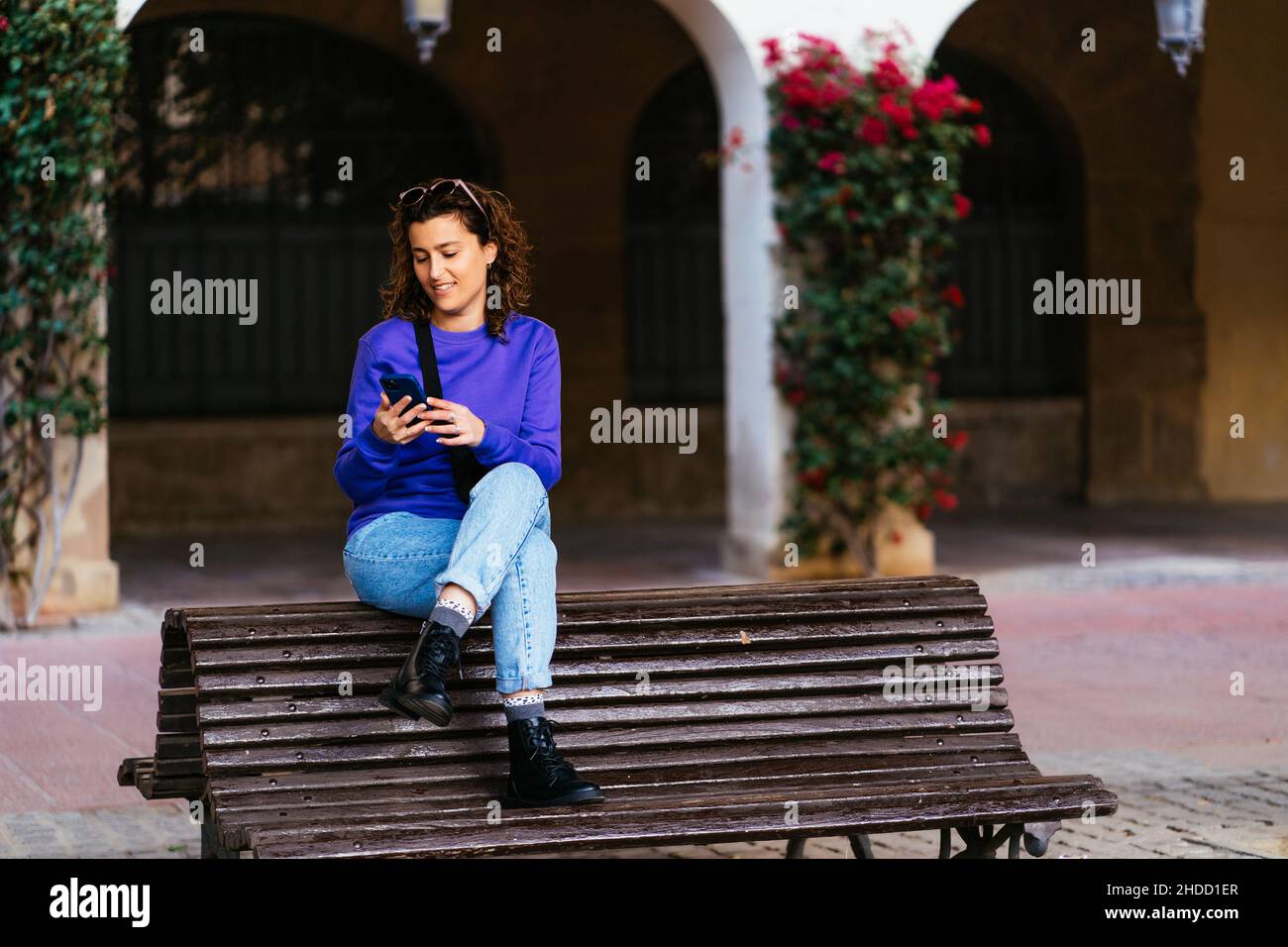 Woman sitting on bench browsing hi-res stock photography and images - Alamy