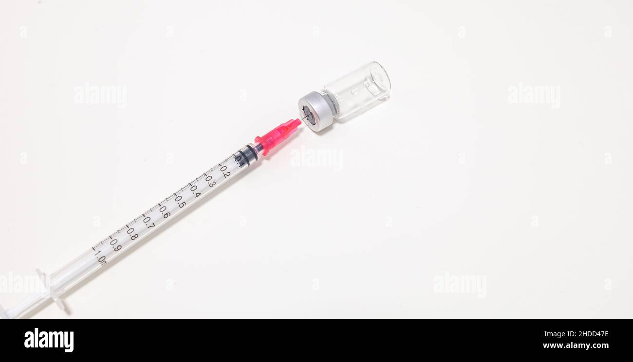 A top view of a medical syringe dialing medicine from a small glass ...