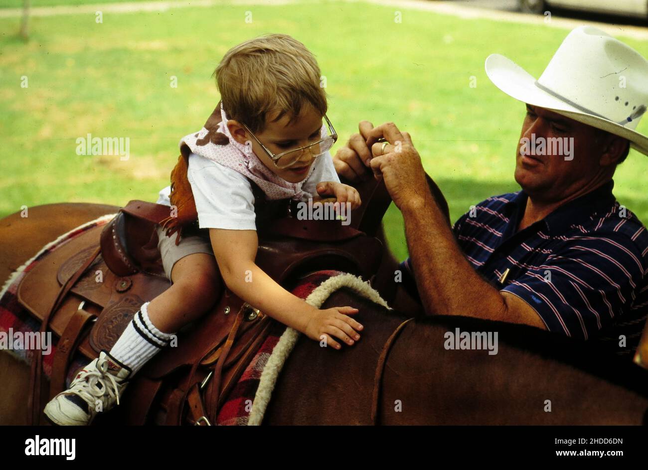 Austin Texas USA, 1992: Male aide helps handicapped child riding a ...