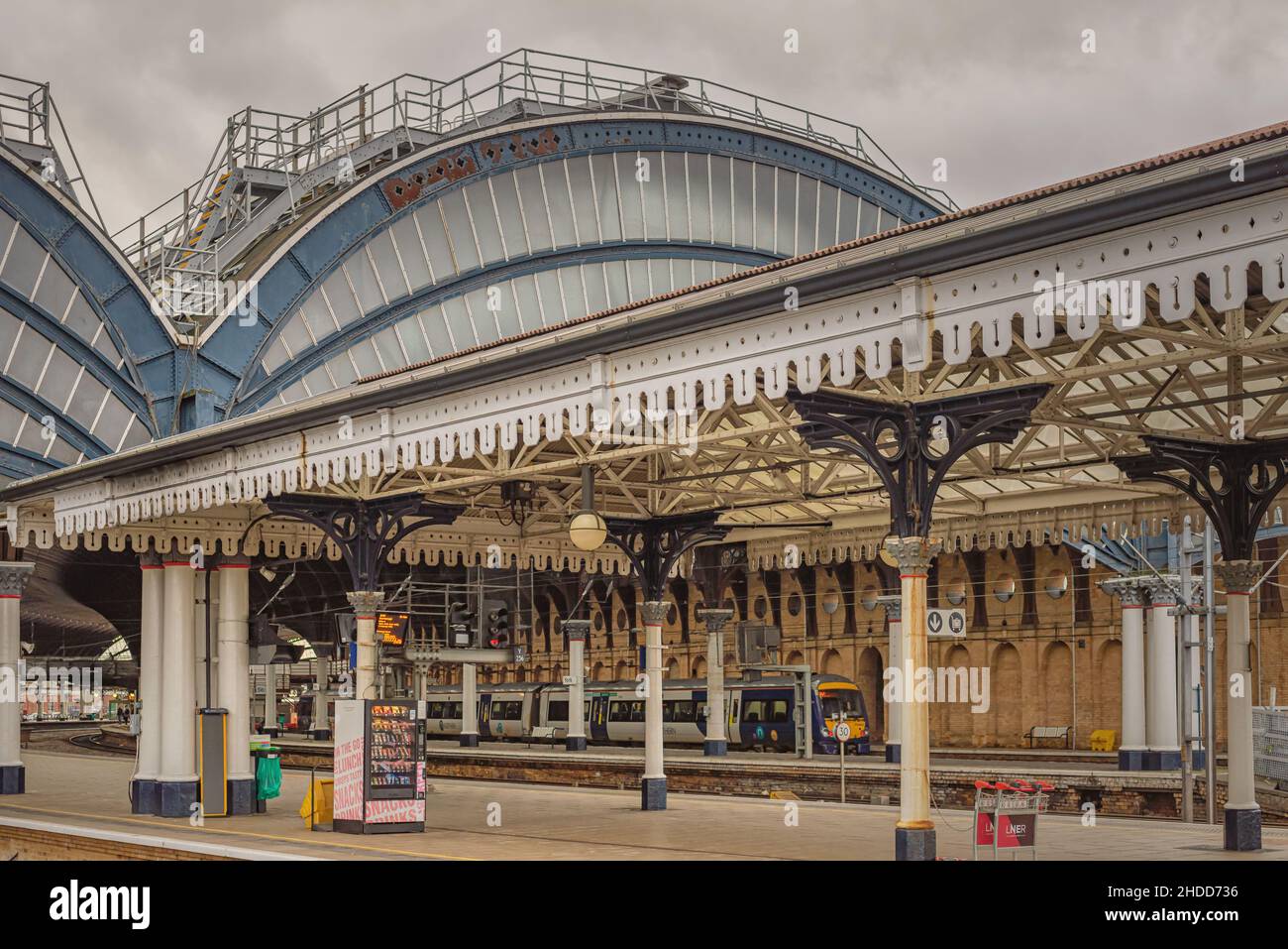 A railway station platform with historic canopies. Columns line the ...