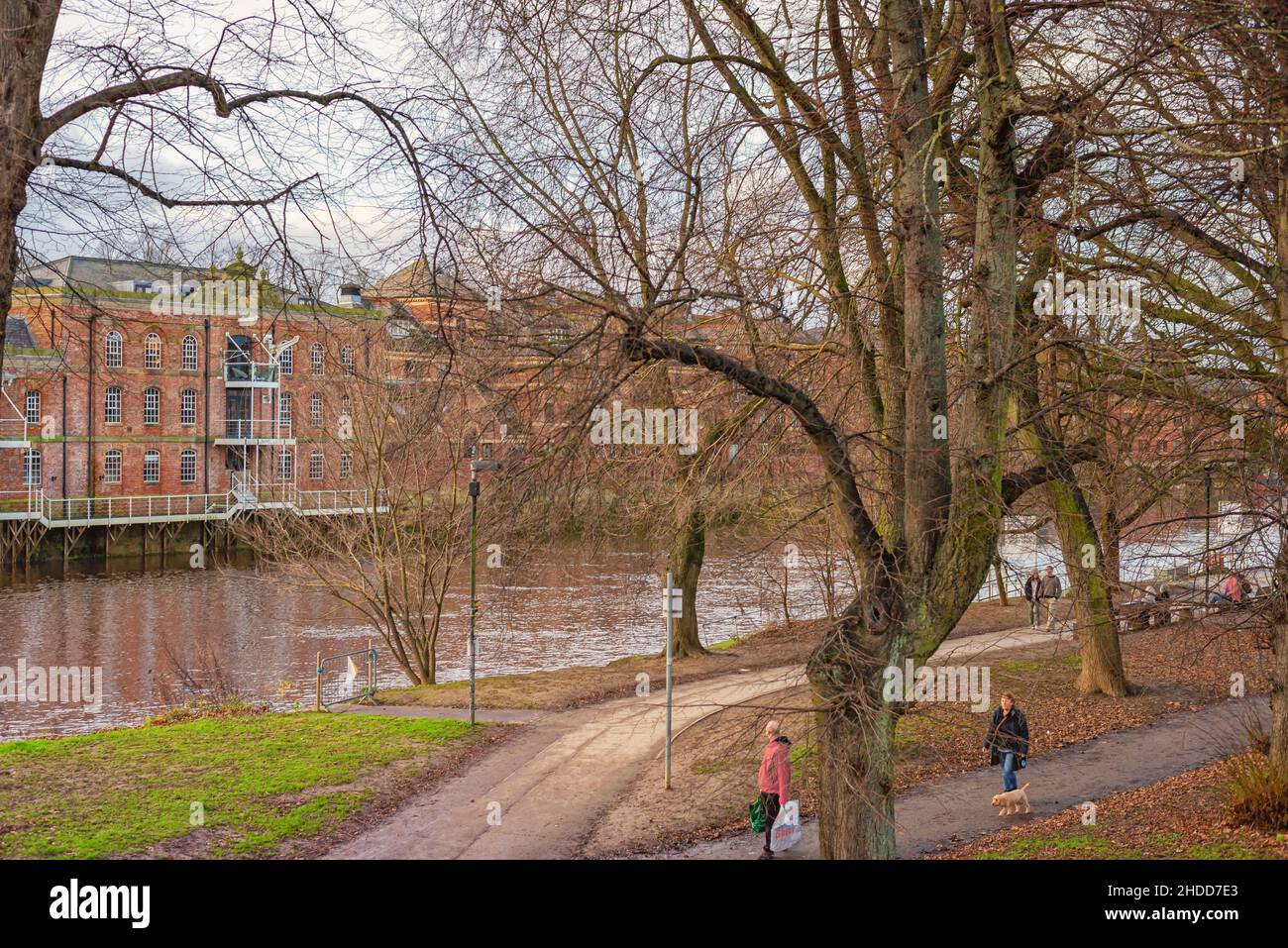 Winter scene of a park with a view across a river to a converted ...