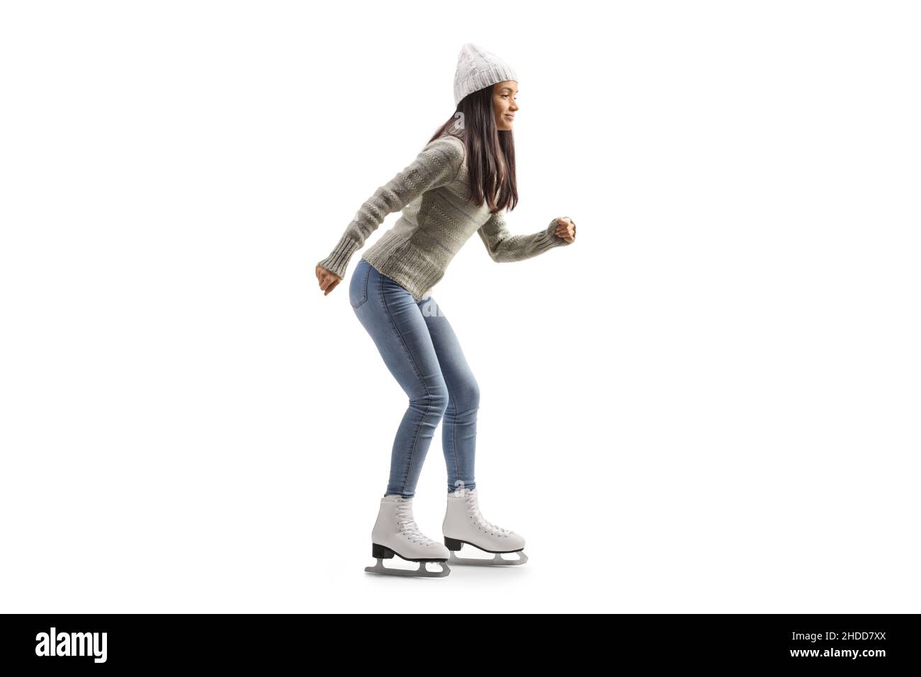 Full length profile shot of a young casual woman ice skating isolated ...