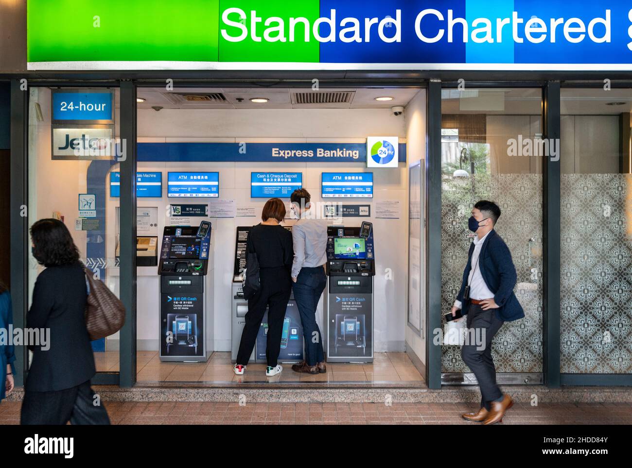 Pedestrians walk past the British multinational banking and financial ...
