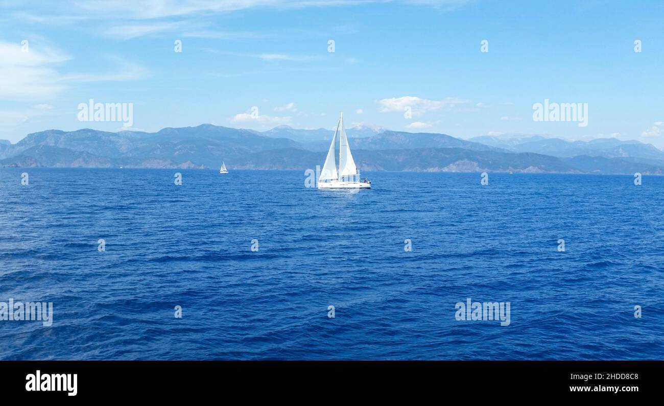 A white sailing boat is sailing in blue sea, a quite, peaceful ...