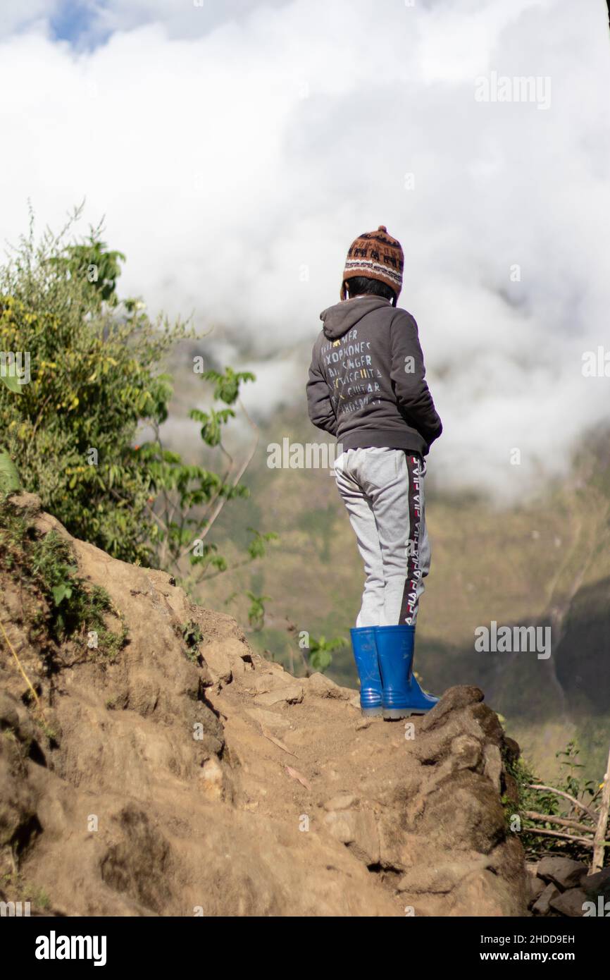 Vertical shot of a young boy looking at the view from the Peruvian ...