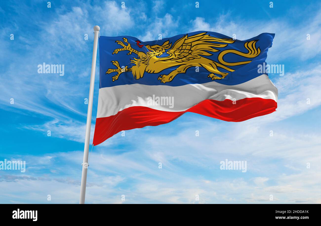 flag of Hansestadt Rostock at cloudy sky background on sunset ...