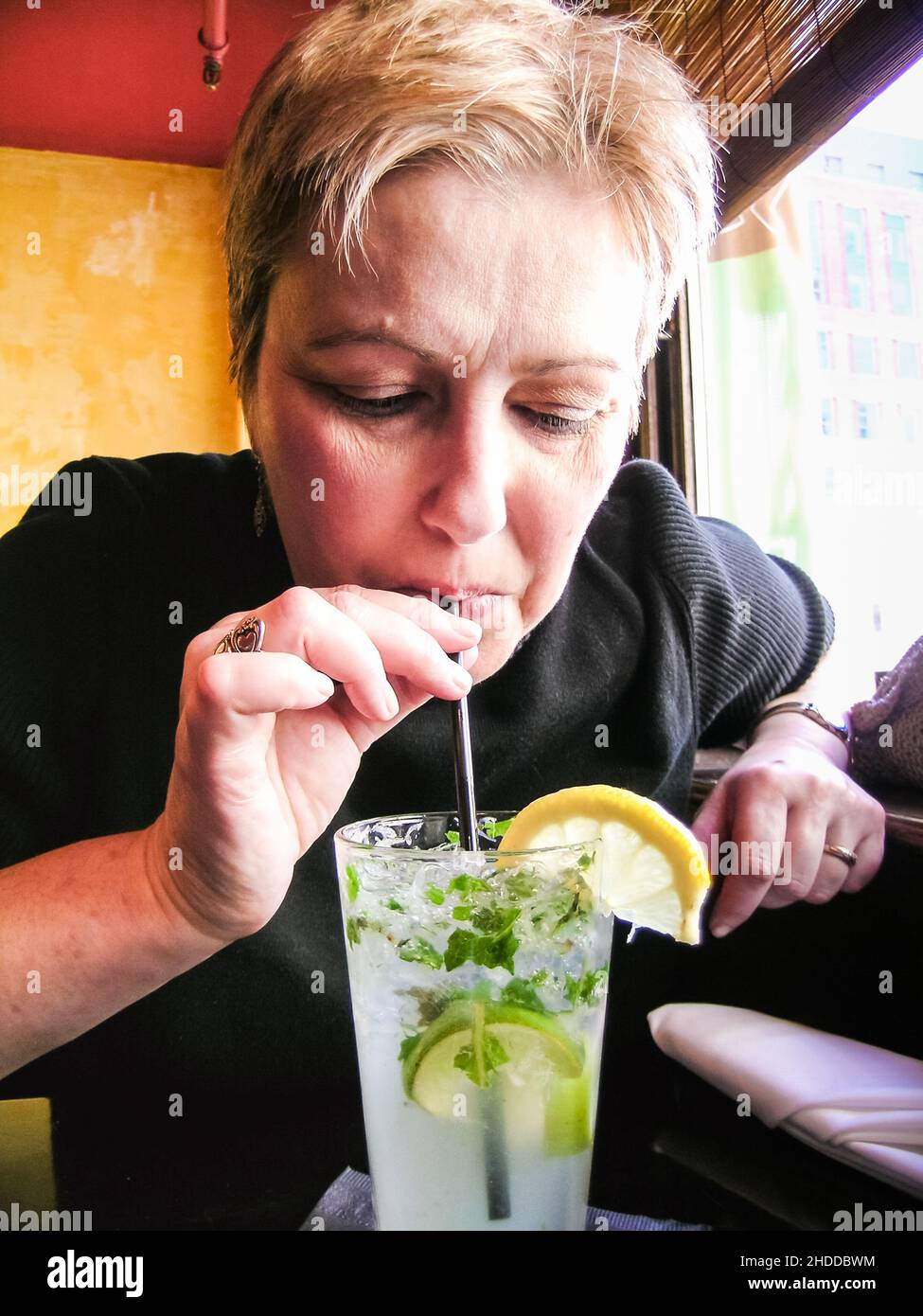 Smiling Mature Woman sipping a beverage Stock Photo - Alamy