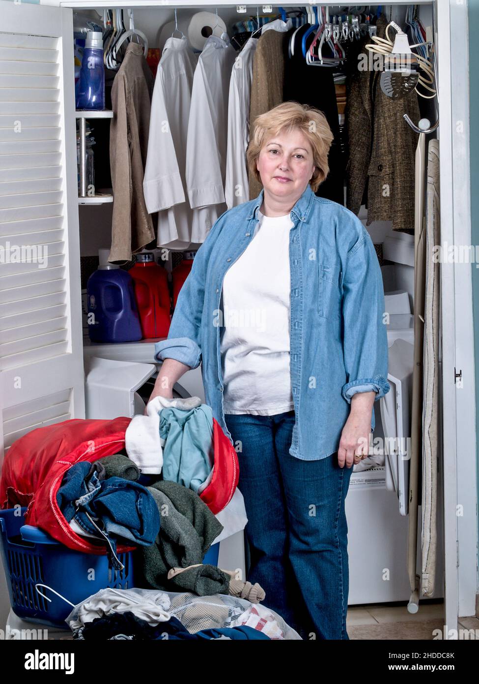 Disgusted Mature Woman reluctantly doing laundry Stock Photo - Alamy