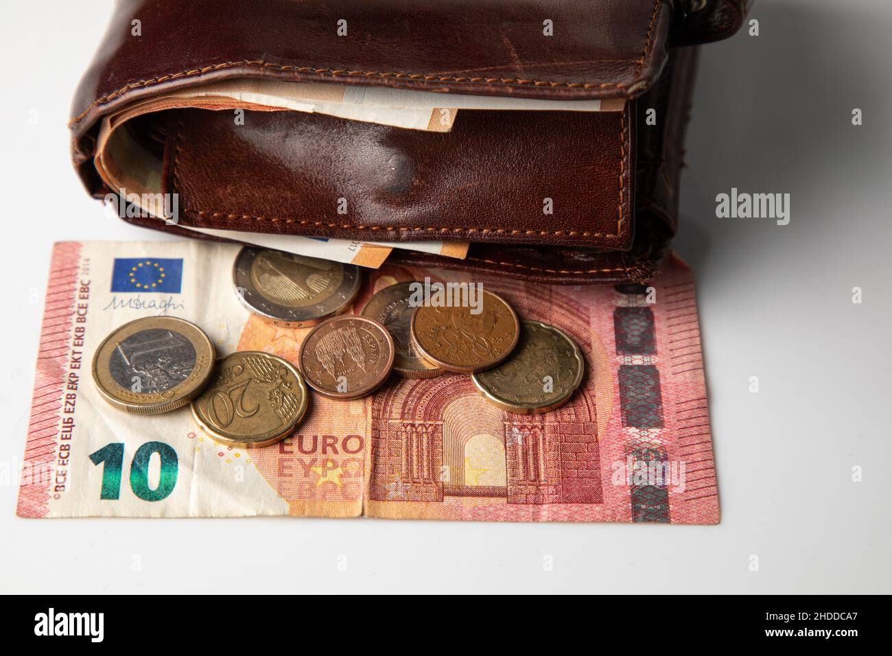 Brown male wallet full of cash on a white background Stock Photo - Alamy