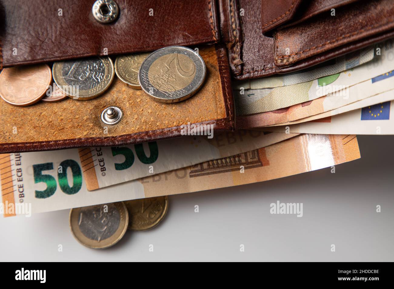 Brown male wallet full of cash on a white background Stock Photo - Alamy