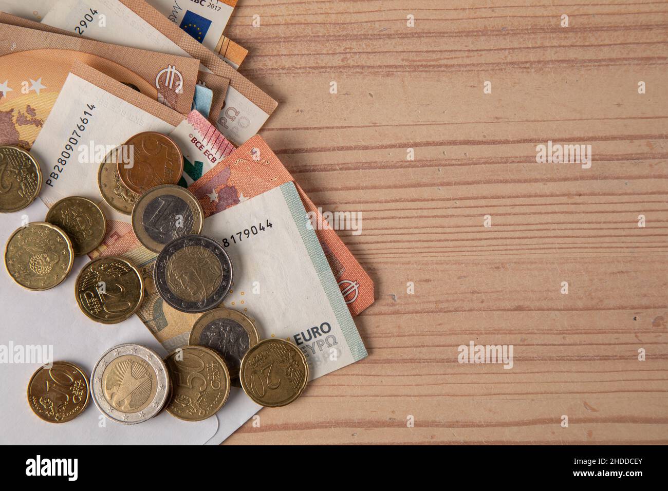 wad of cash in a white envelope on wooden table Stock Photo - Alamy