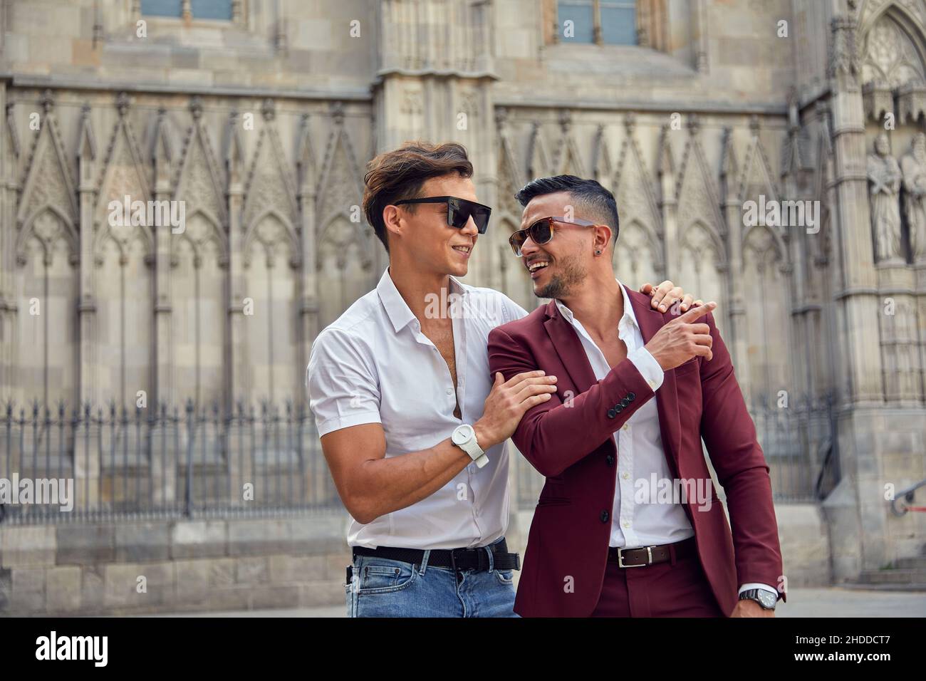 Young males in formal clothes hugging each other and walking on a ...