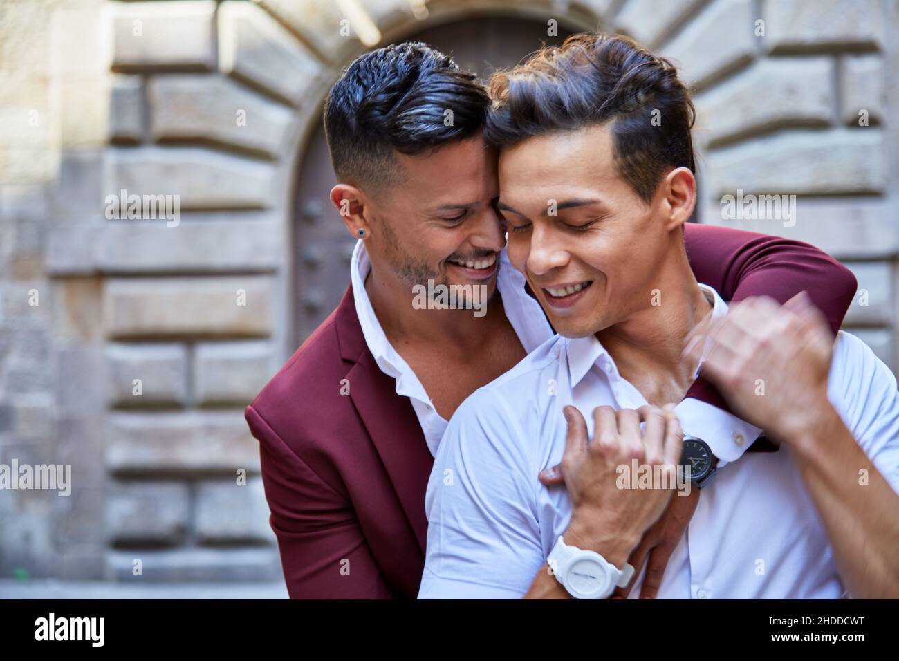 Young males in formal clothes hugging each other and walking on a ...