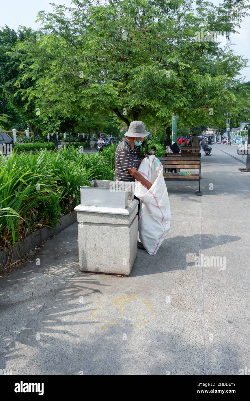 The old man works as a garbage Scavenger to earn money. Poverty in ...