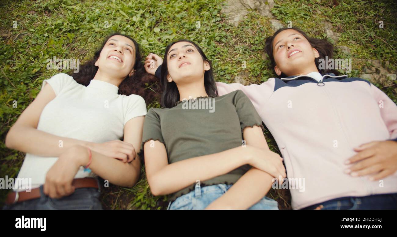 Group of Indian female friends laying and talking on a f Stock Photo ...