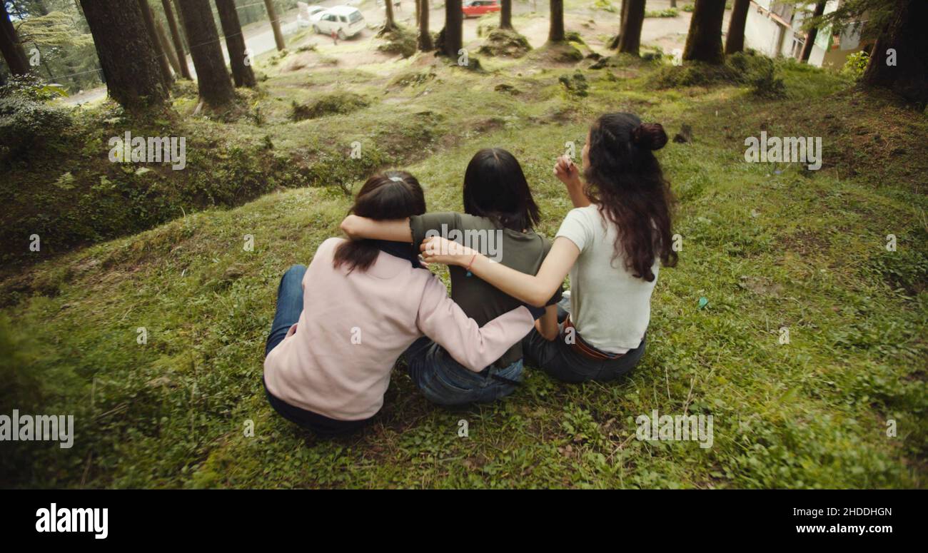 Group of Indian female friends sitting and hugging in a park Stock ...