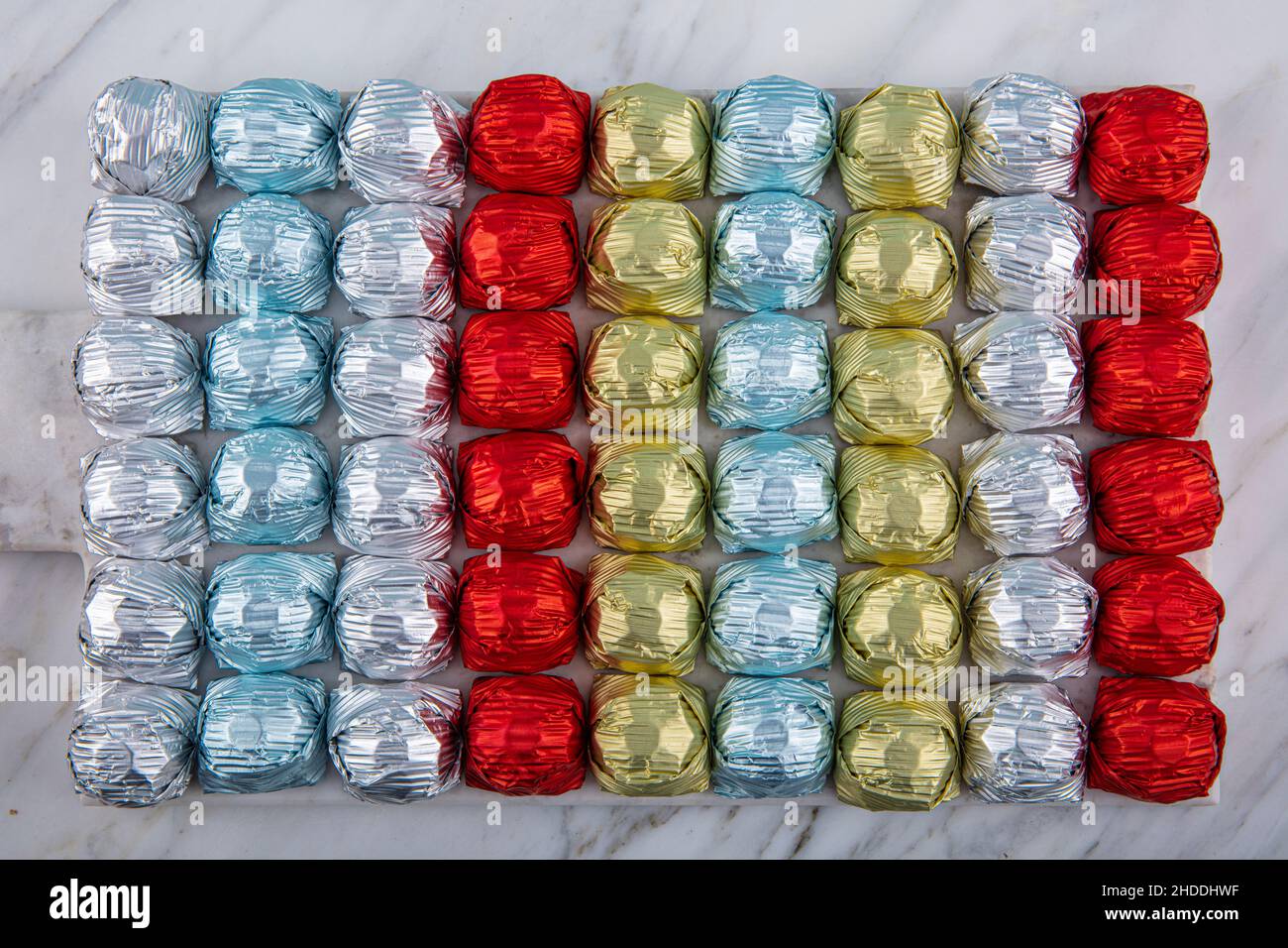 Round chocolate balls with aluminum wrapping foil in box container on ...