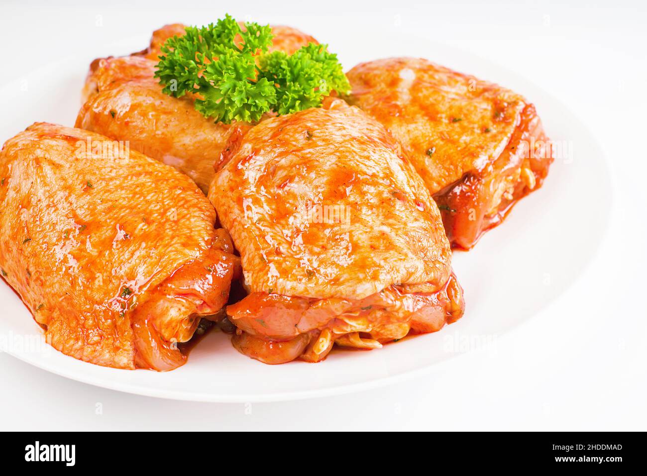 Chicken semi-cooked thighs.Raw marinated in red sauce chicken thighs on ...