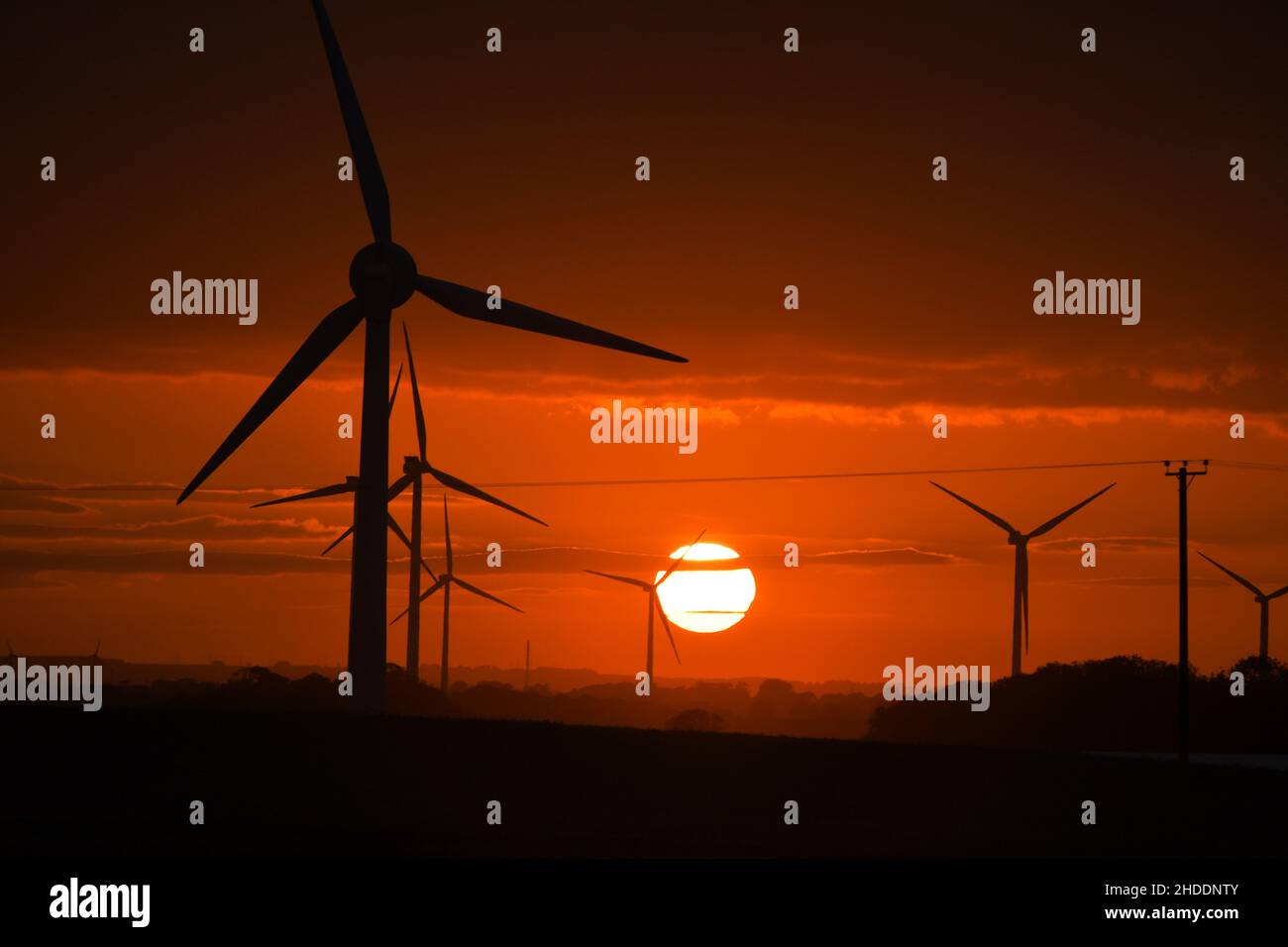 Dramatic sunset behind giant wind turbines Stock Photo - Alamy