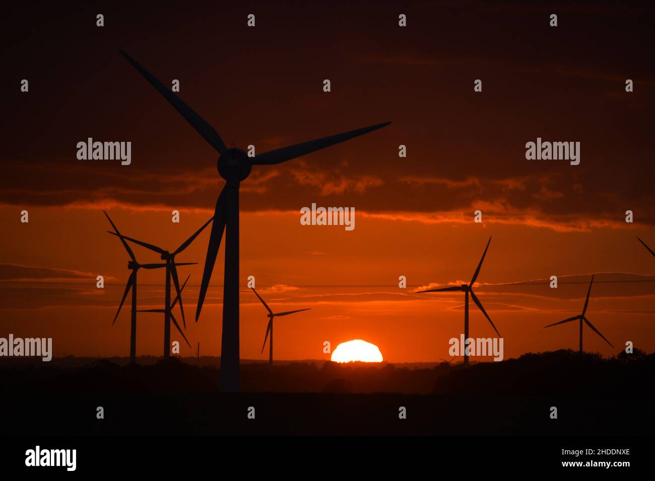 Dramatic sunset behind giant wind turbines Stock Photo - Alamy