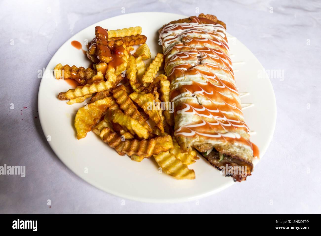 Fries with brizol, meal in Kyrgyzstan. Brizol is a meat and egg roll ...