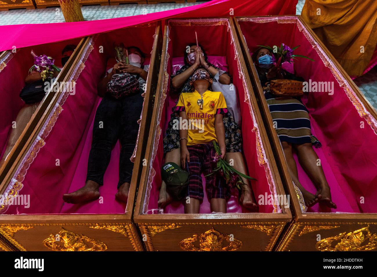 Thai family seen laying in coffins as a part of the resurrection ritual ...