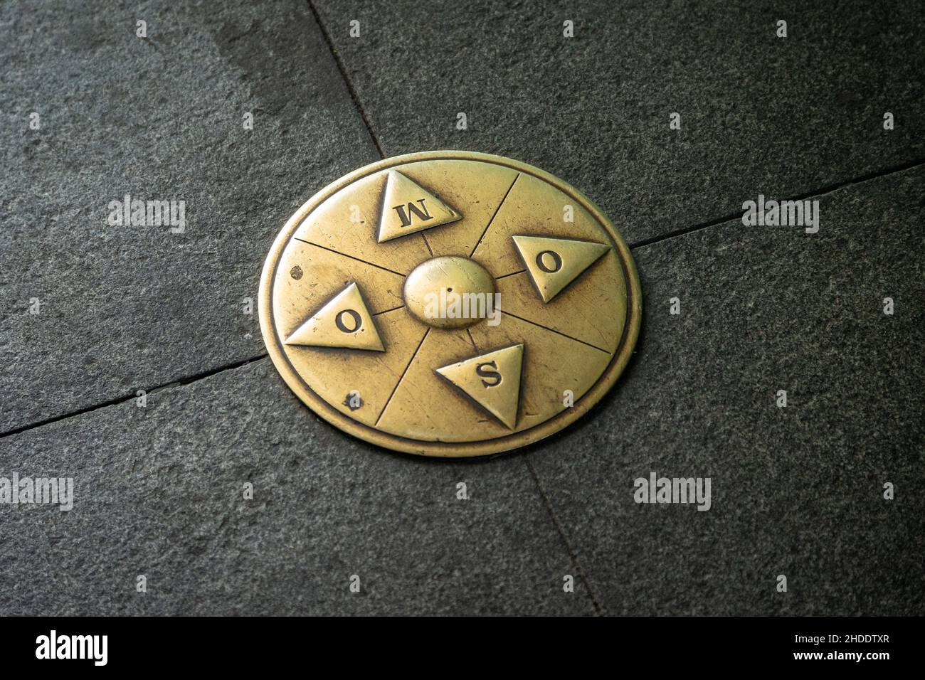 Closeup of a small gold metal design on the pavement in the shape of a ...