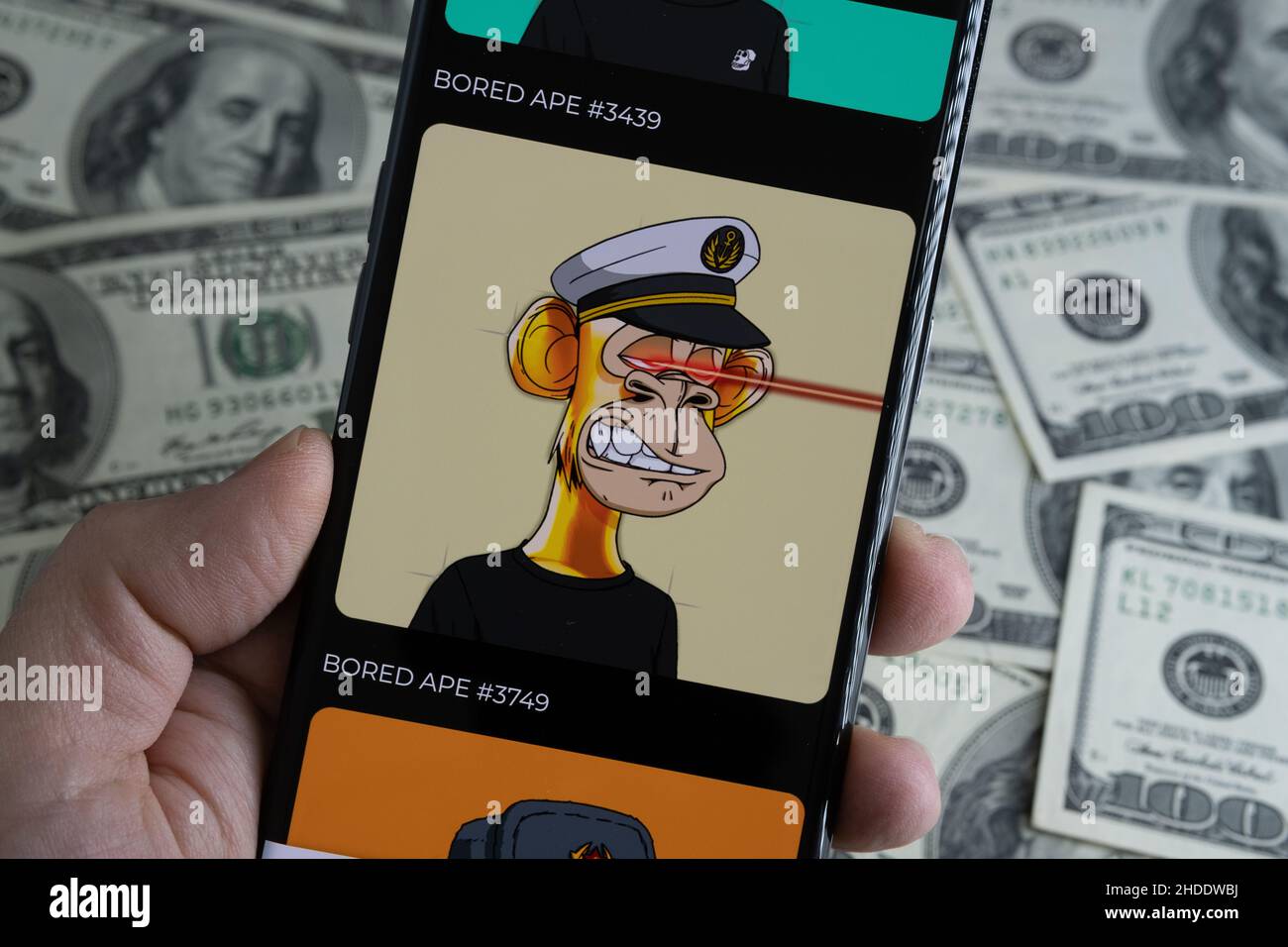 Bored Ape Yacht Club #3749 NFT seen on smartphone and blurred dollars ...