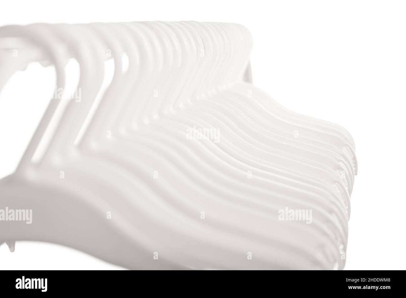 Abstract white plastic hangers for clothes hanging on rod from clothing ...