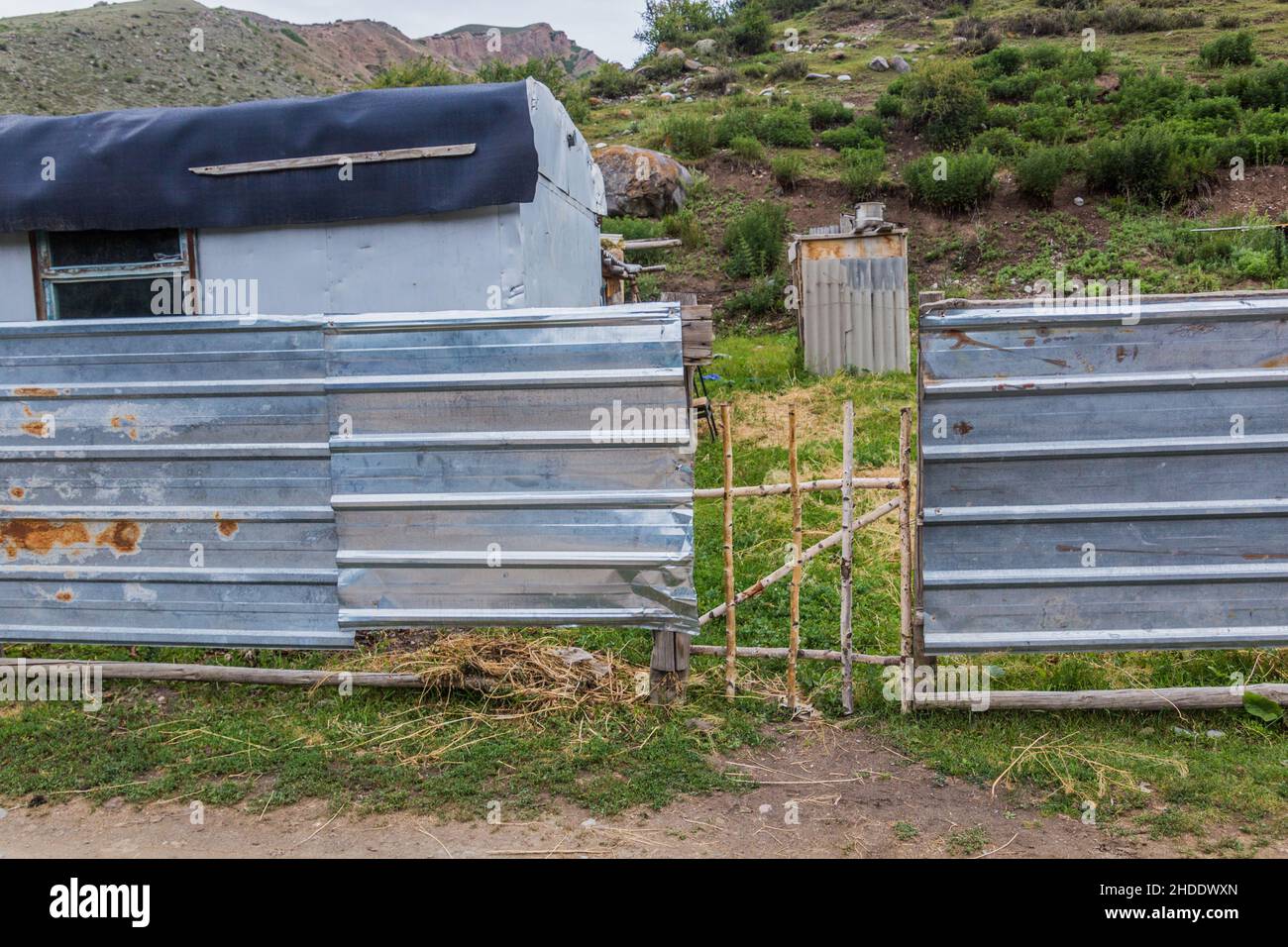 Settlement behind a metal sheet fence in the Karakol valley in ...