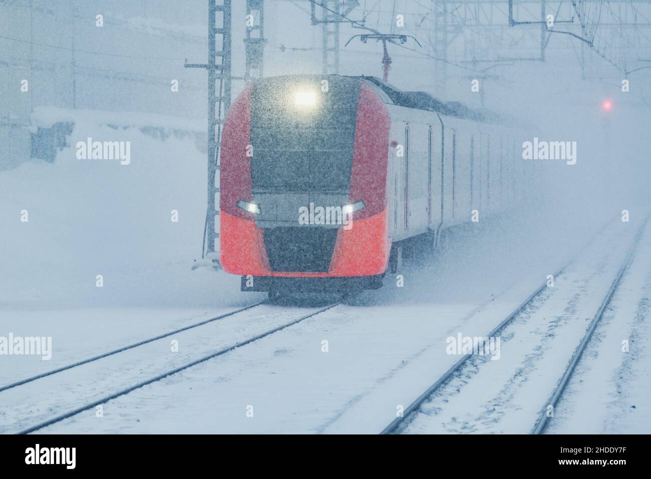 Highspeed train approaches to the station at cold snowstorm Stock Photo ...