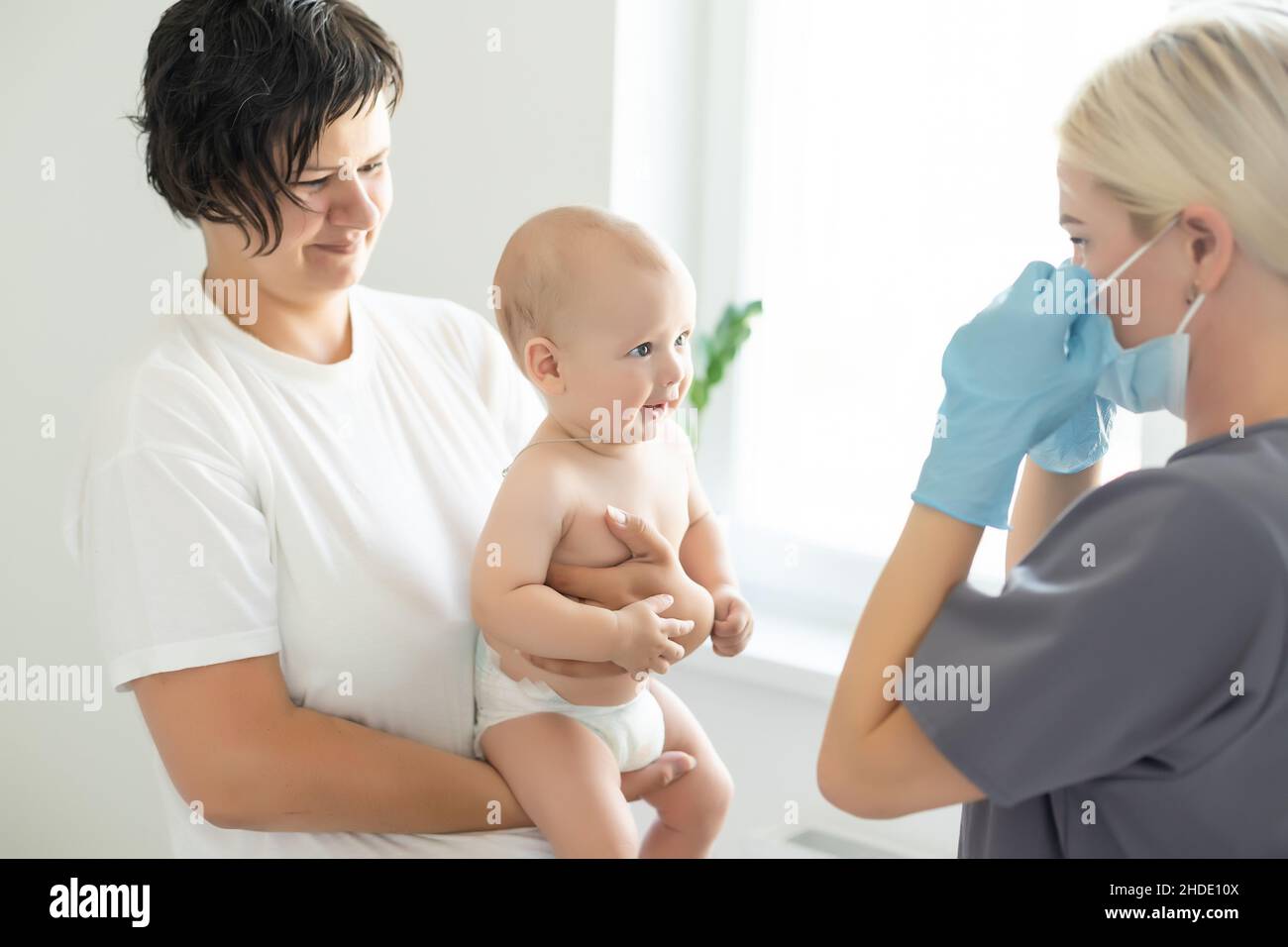 Pediatrician doctor with syringe, tense mother and baby Stock Photo - Alamy