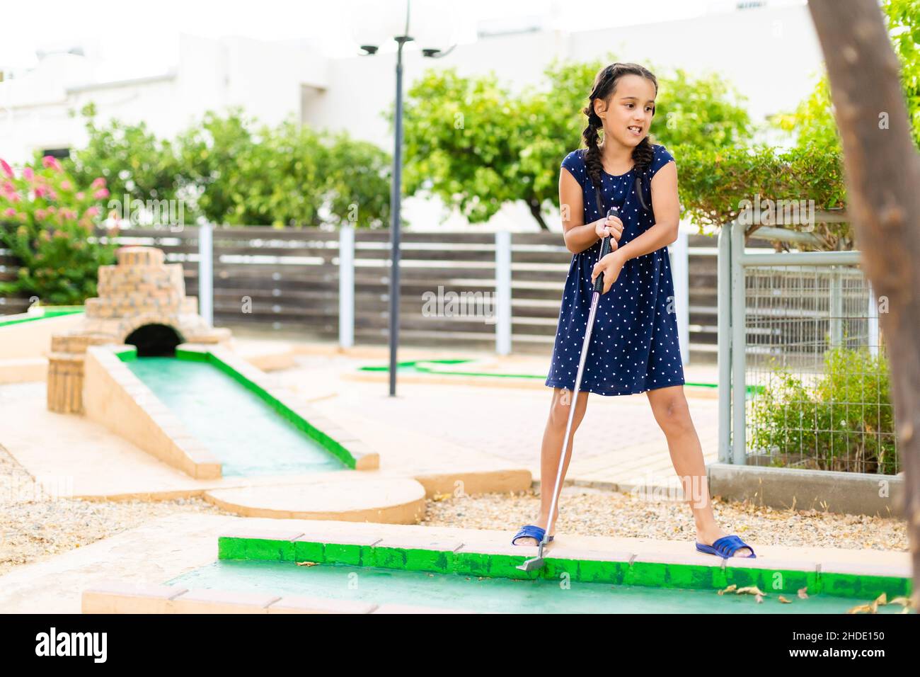 Cute little girl playing mini golf in a park Stock Photo - Alamy