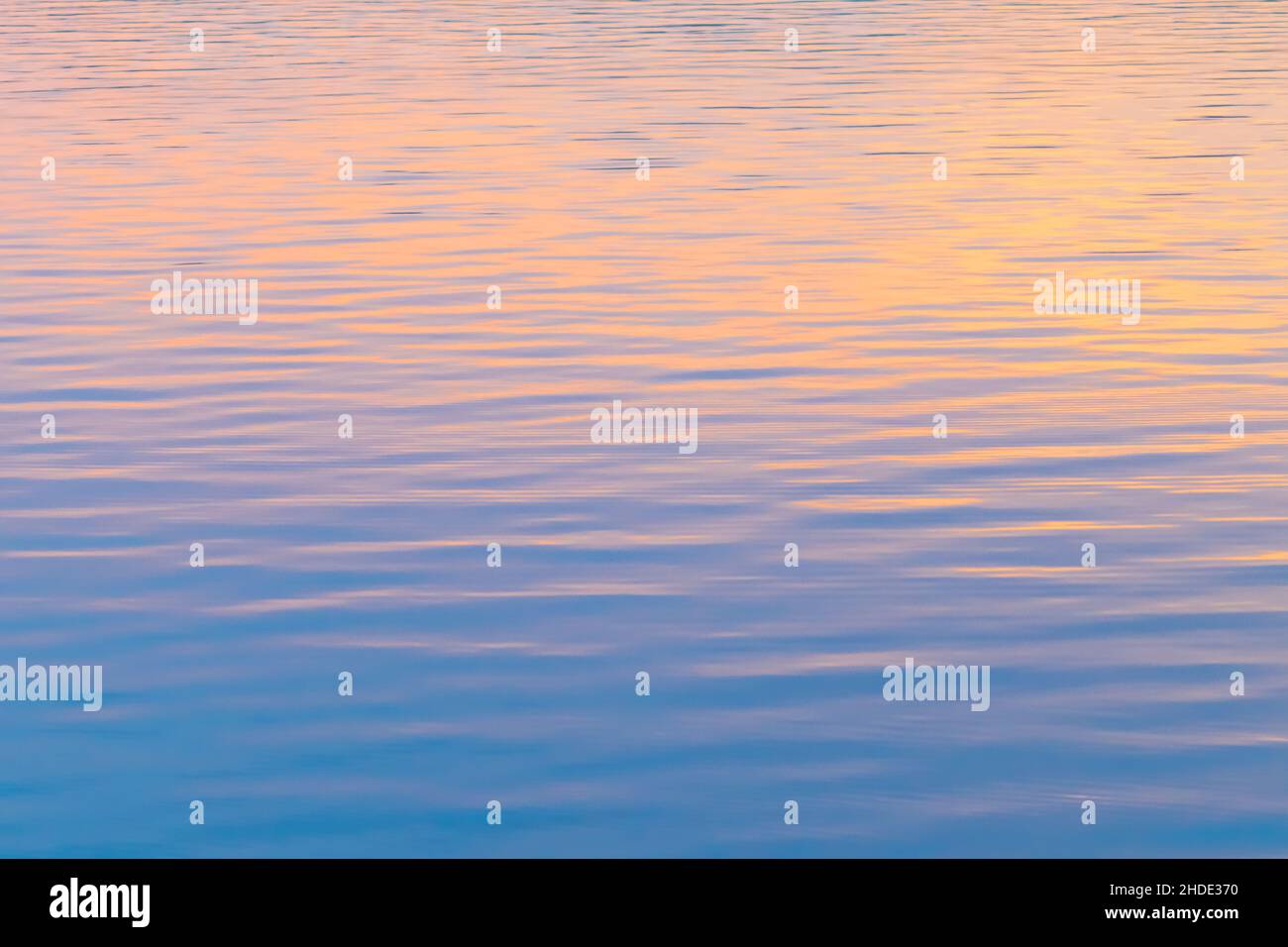Sunset colors reflected on ripples on water surface Stock Photo - Alamy