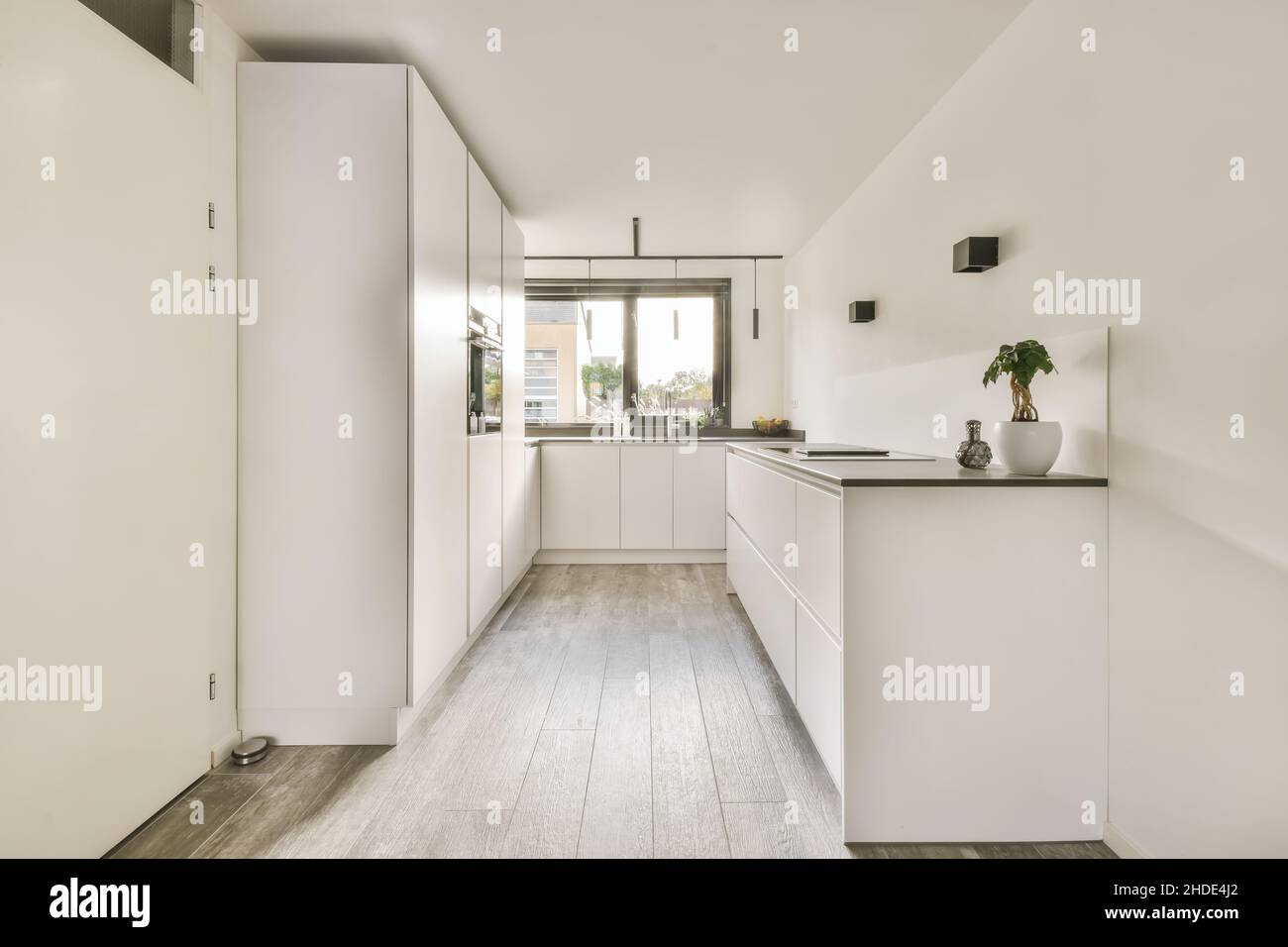 Snow-white kitchen set with dark countertop and wooden parquet floor ...