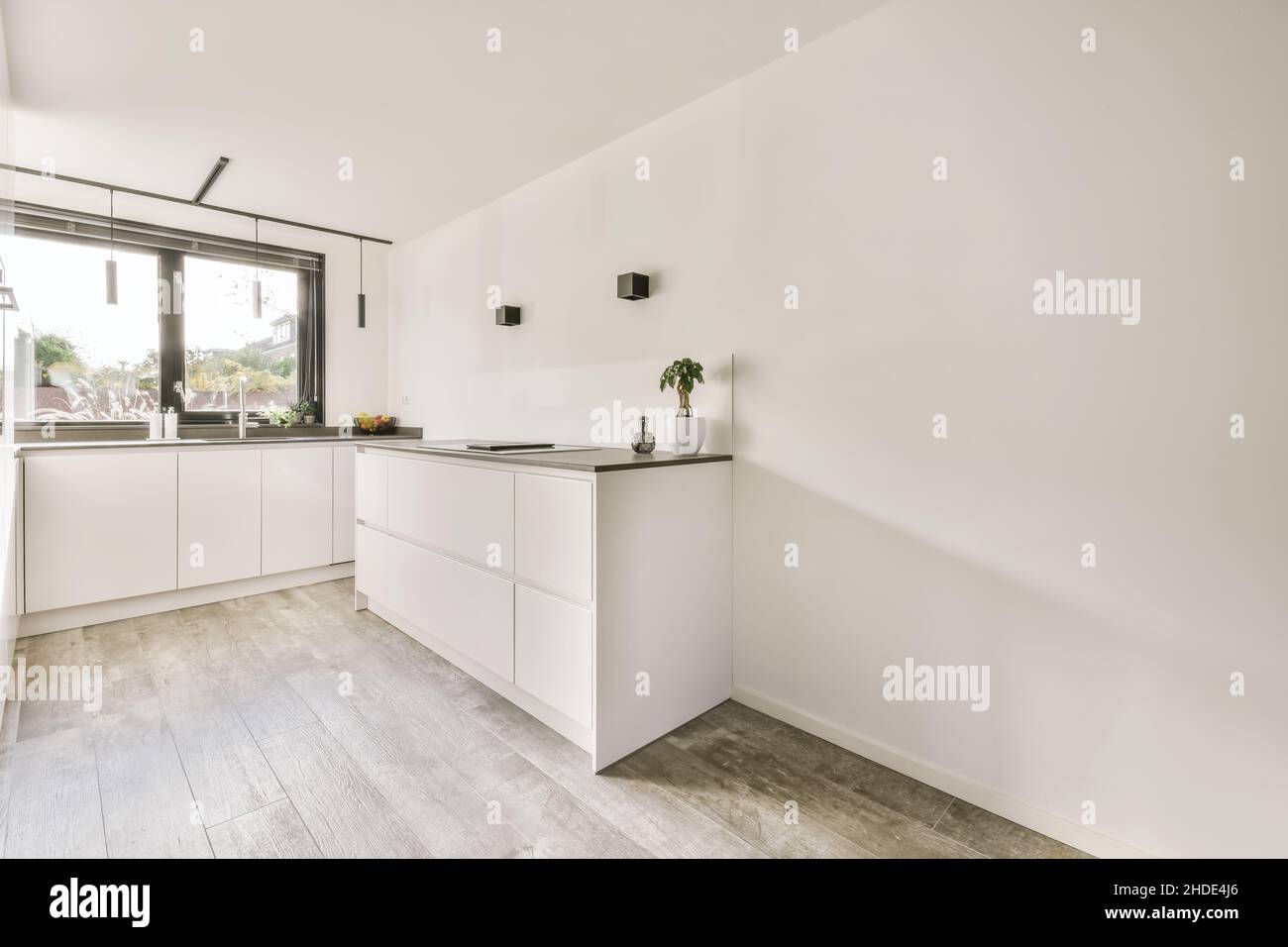 Snow-white kitchen set with dark countertop and wooden parquet floor ...