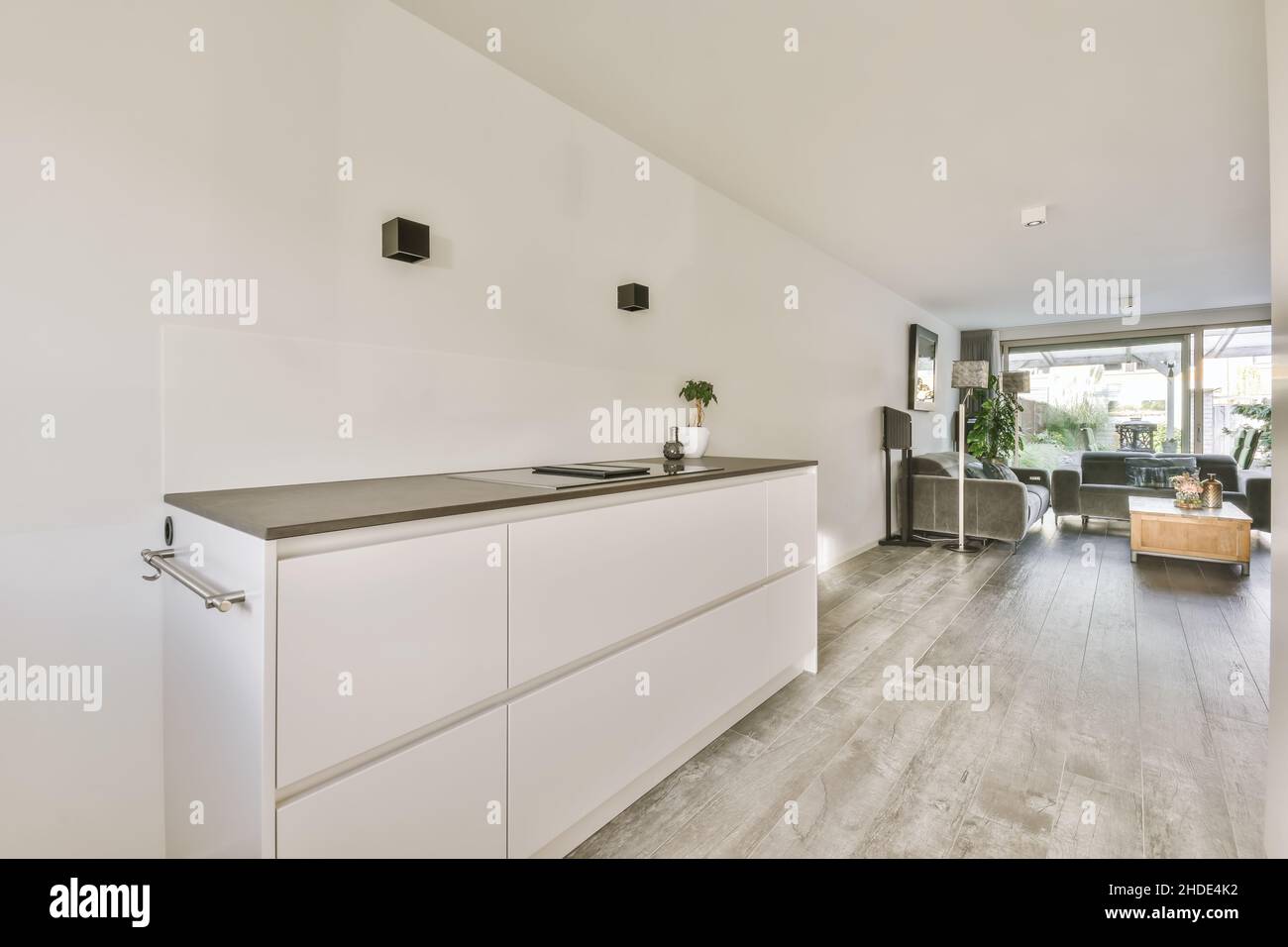 Snow-white kitchen set with dark countertop and wooden parquet floor ...