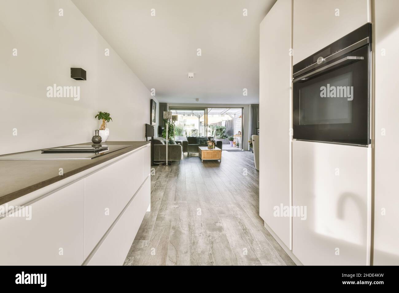 Snow-white kitchen set with dark countertop and wooden parquet floor ...