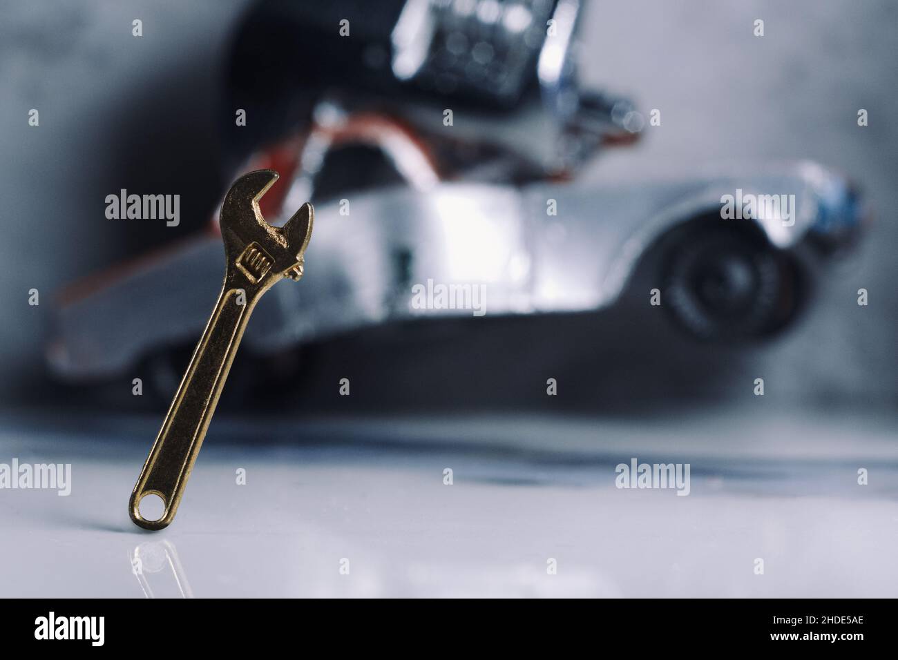Macro concept giant wrench destroys toy car at crooked car mechanic ...