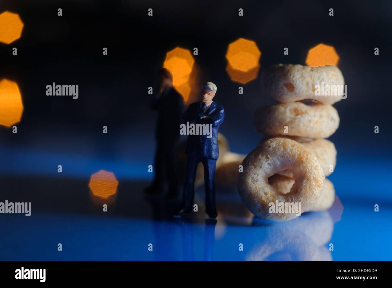 Miniature businessmen inspect toasted oat loop cereal for quality ...