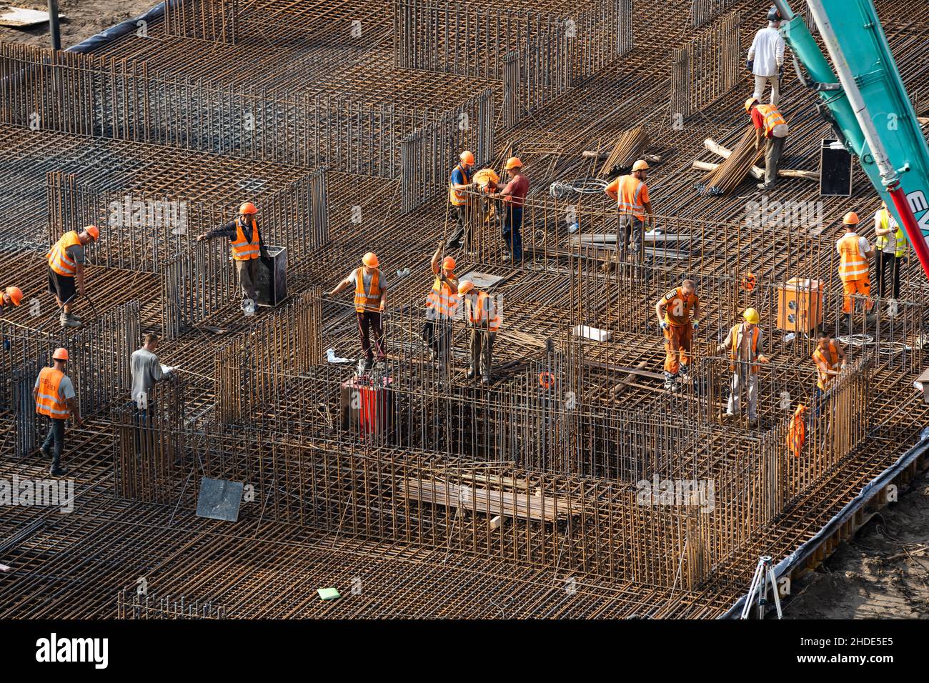 concreting work: construction site worker during concrete pouring into ...