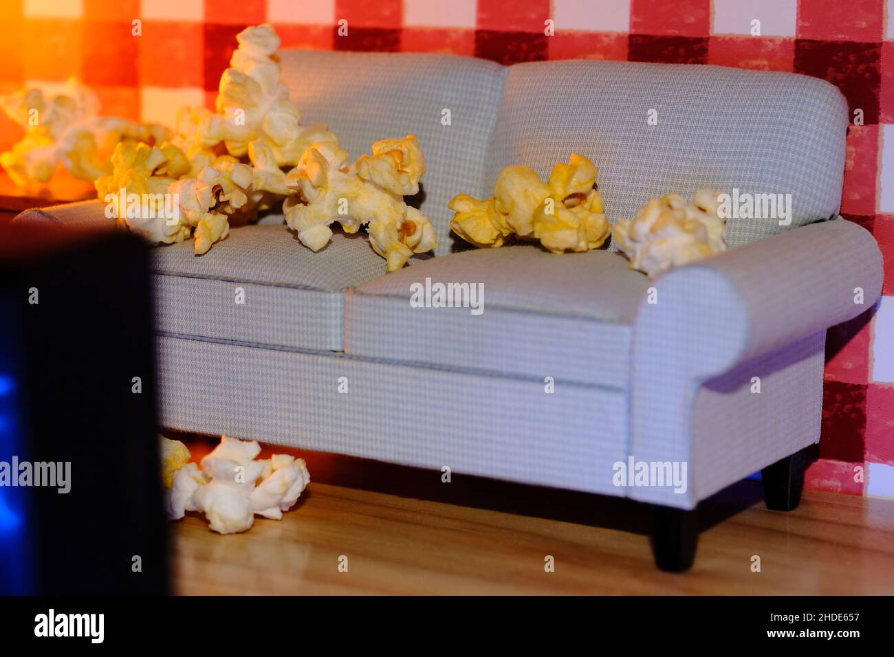 Movie and chill concept with popcorn on miniature couch watching the TV ...
