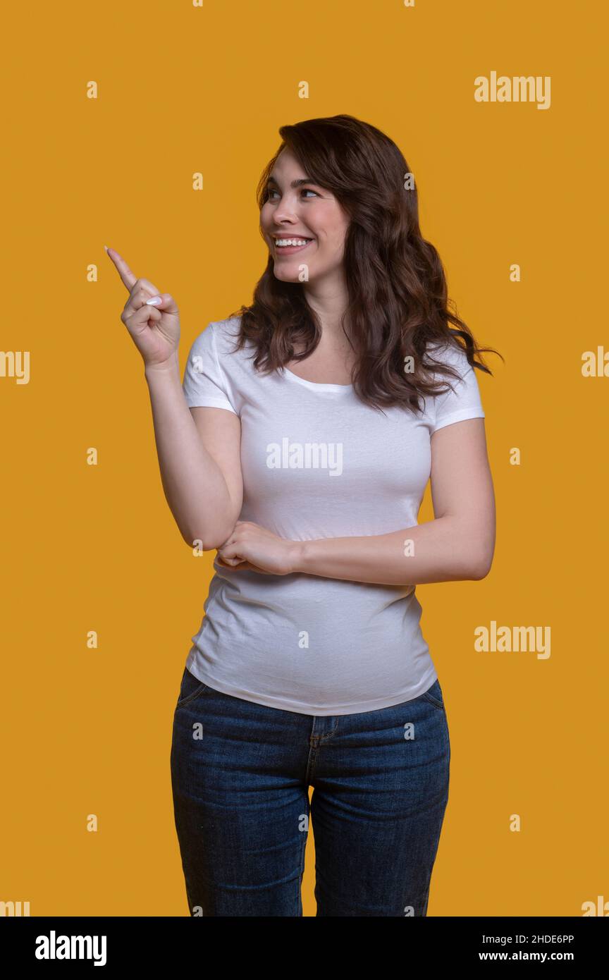 Girl showing the direction with a raised forefinger Stock Photo - Alamy