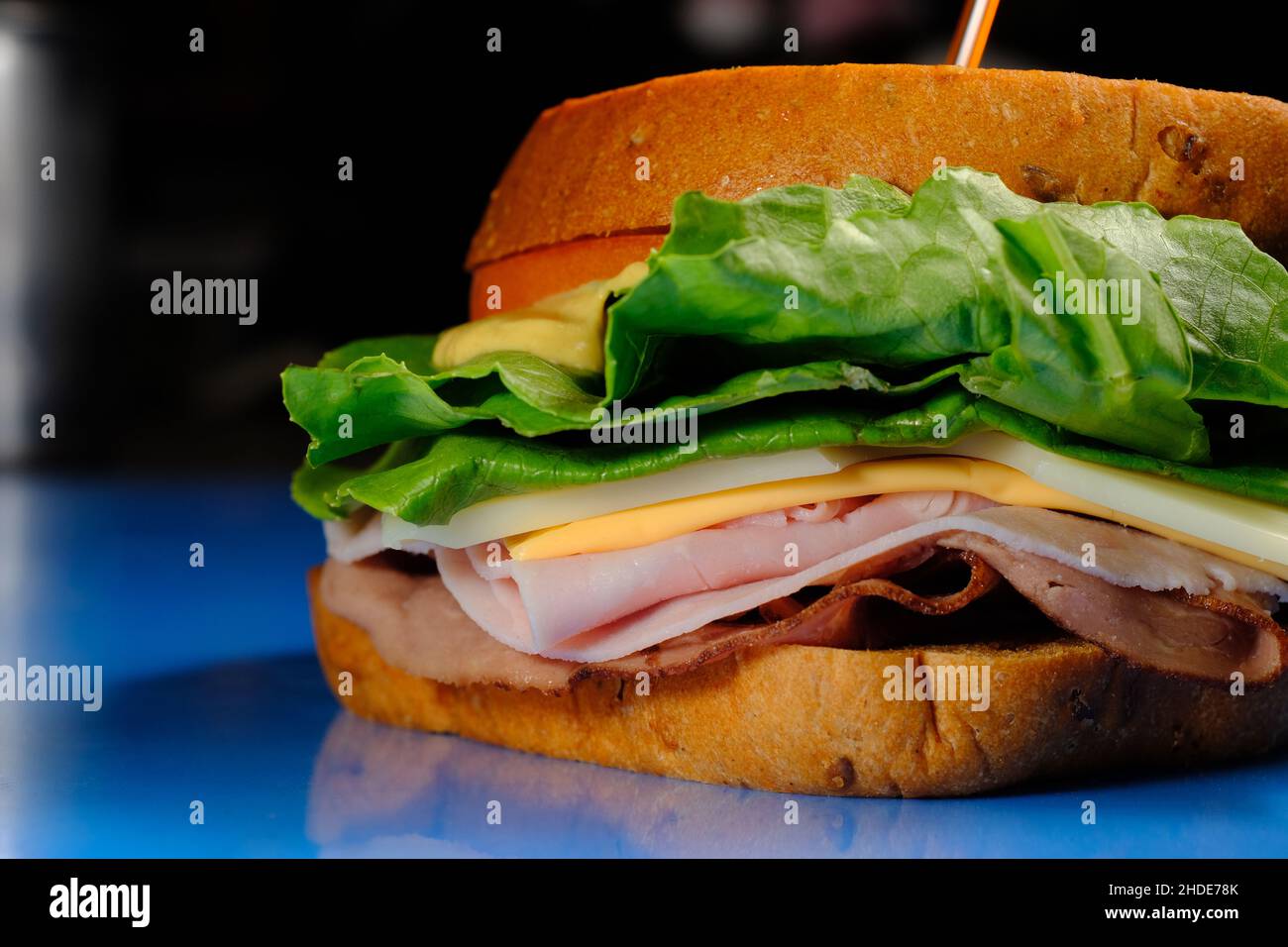 Ham and roast beef sandwich with American cheese and a cocktail sword ...